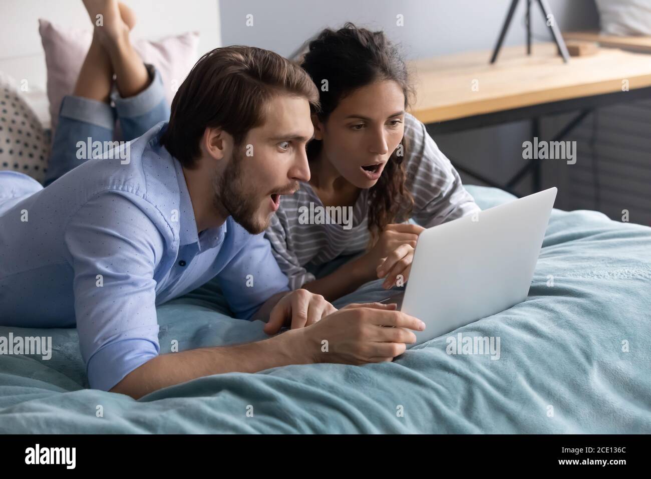Surprised young family couple looking at computer screen Stock Photo ...