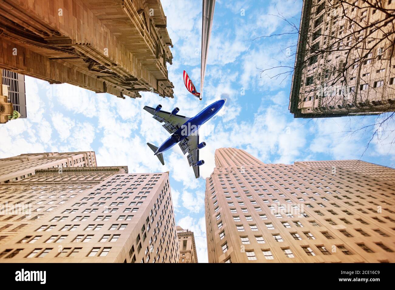 Plane over sky between skyscraper buildings and USA American flag in ...