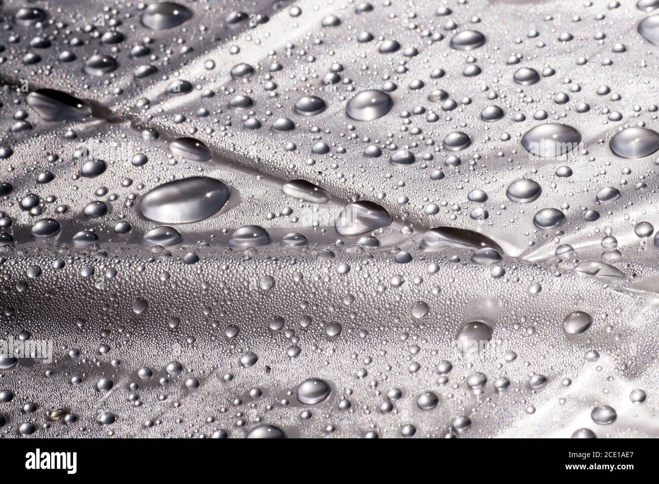 Water drops on the surface covered with foil. Surface tension Stock ...