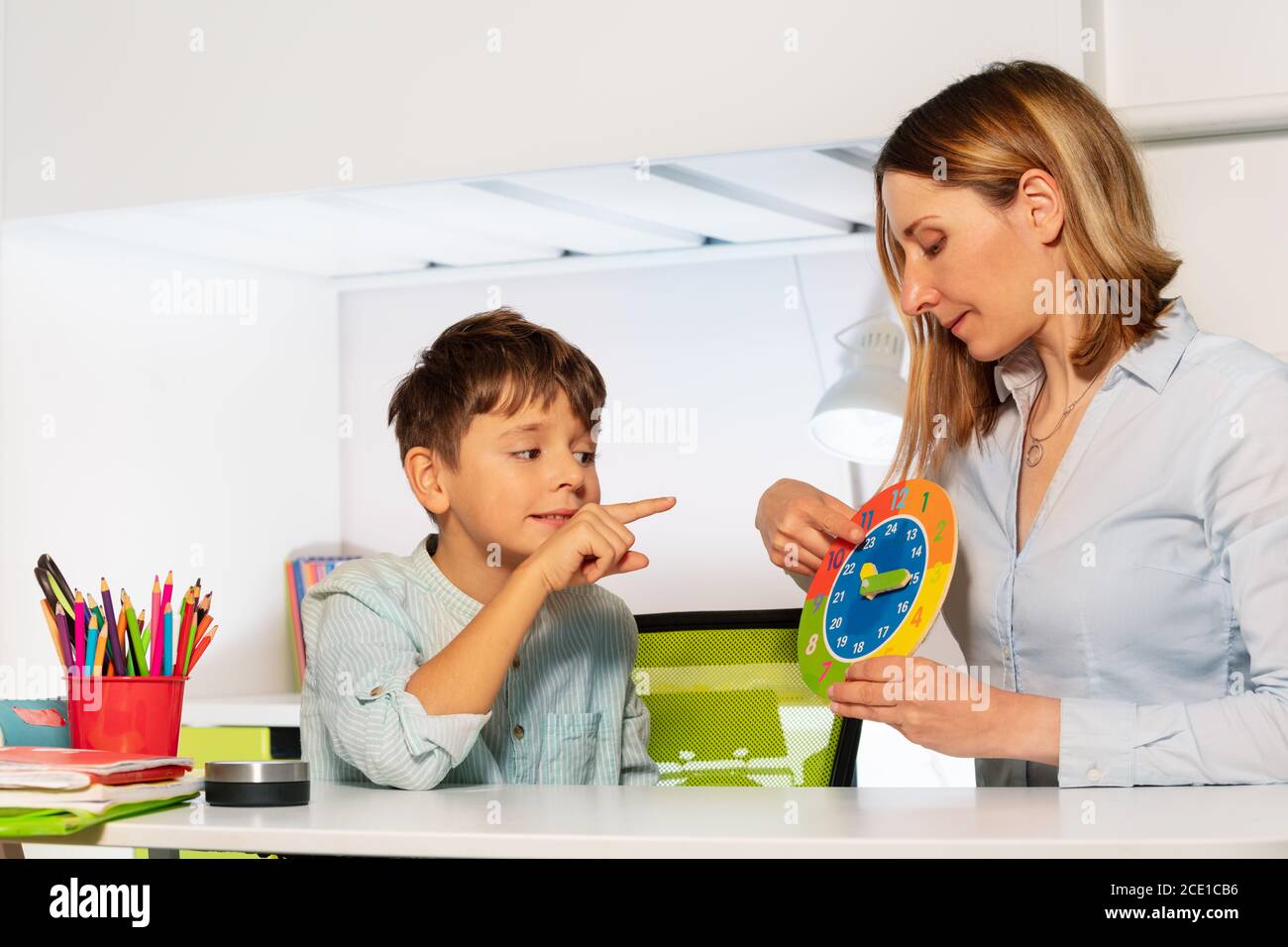 Child with autism spectrum disorder learn clock and hours, teacher ...