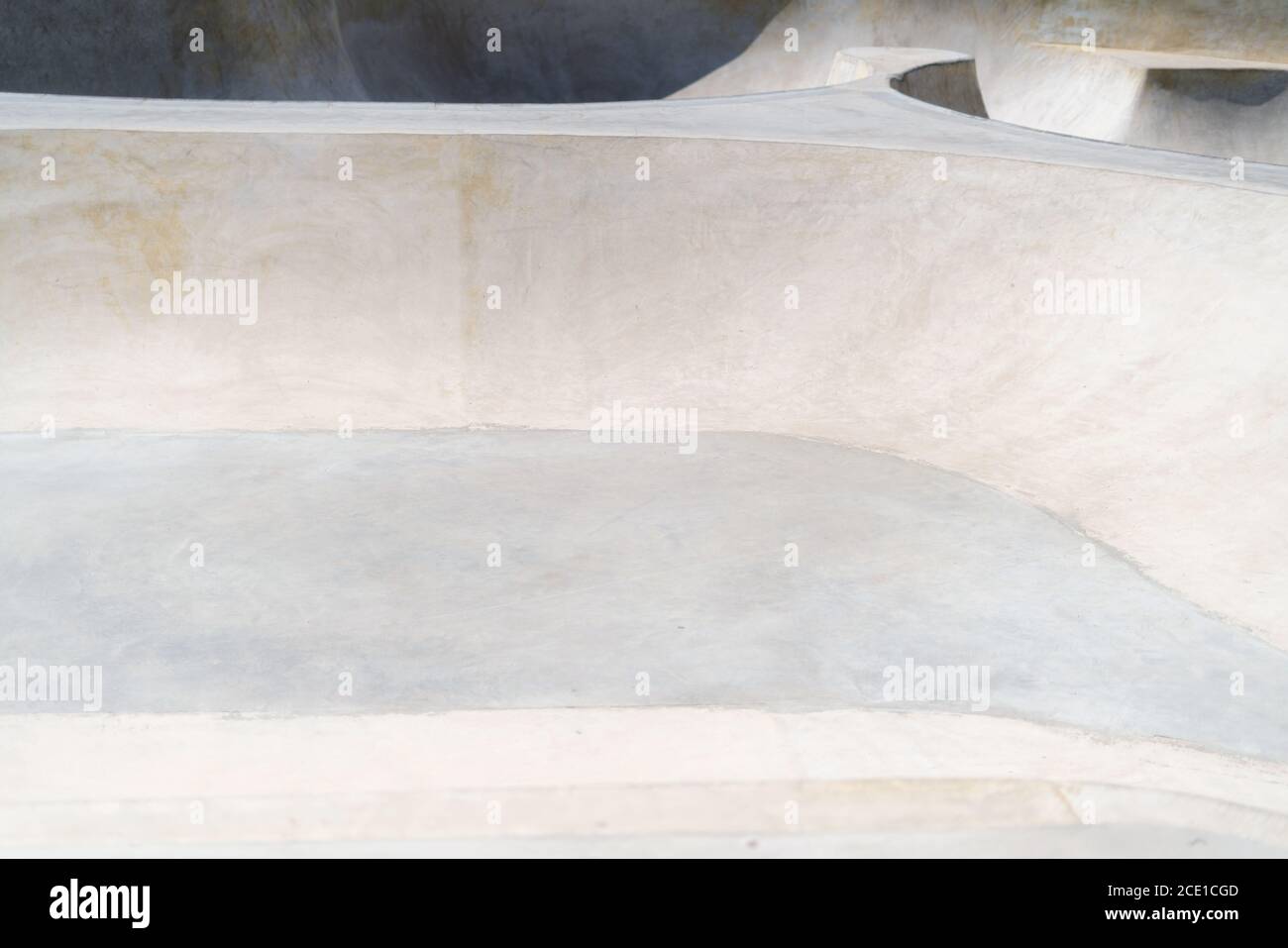 Concrete public skate park on a sunny day. Cement ramps for ...