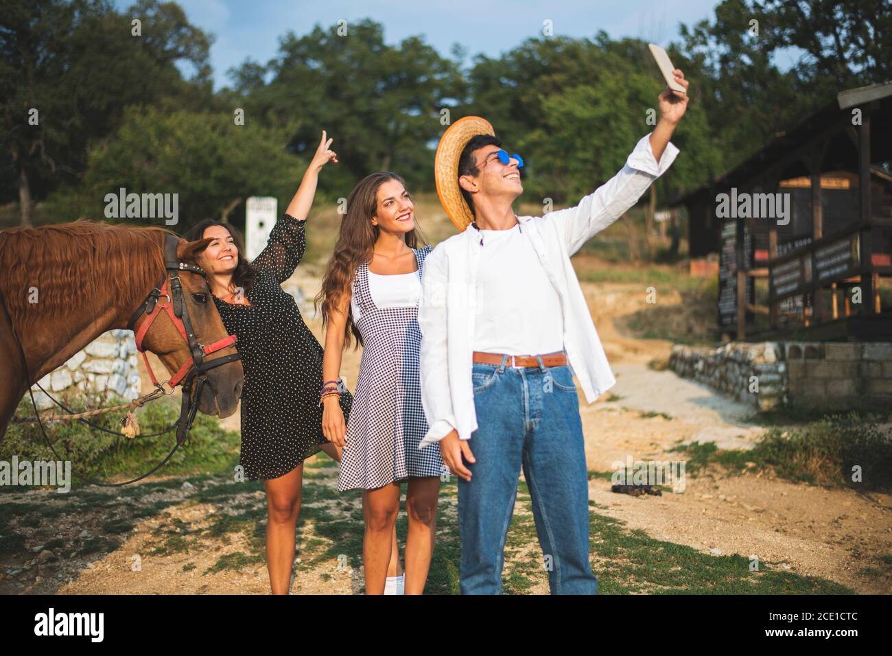 Three Friends Using Smart Phone for Photograph With the Horse. Ranch ...