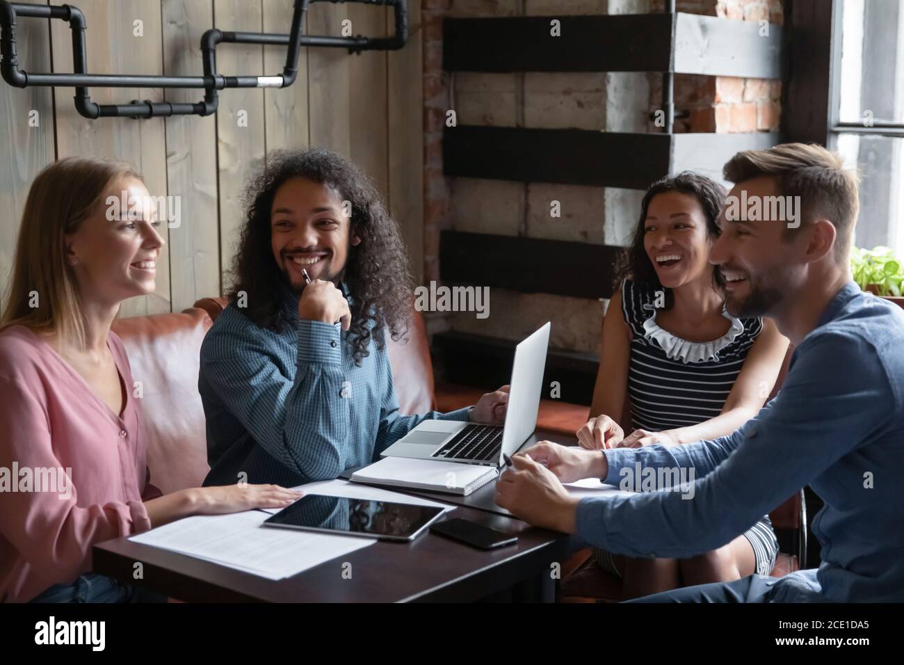 Happy diverse colleagues listening to leader at meeting in cafe Stock ...