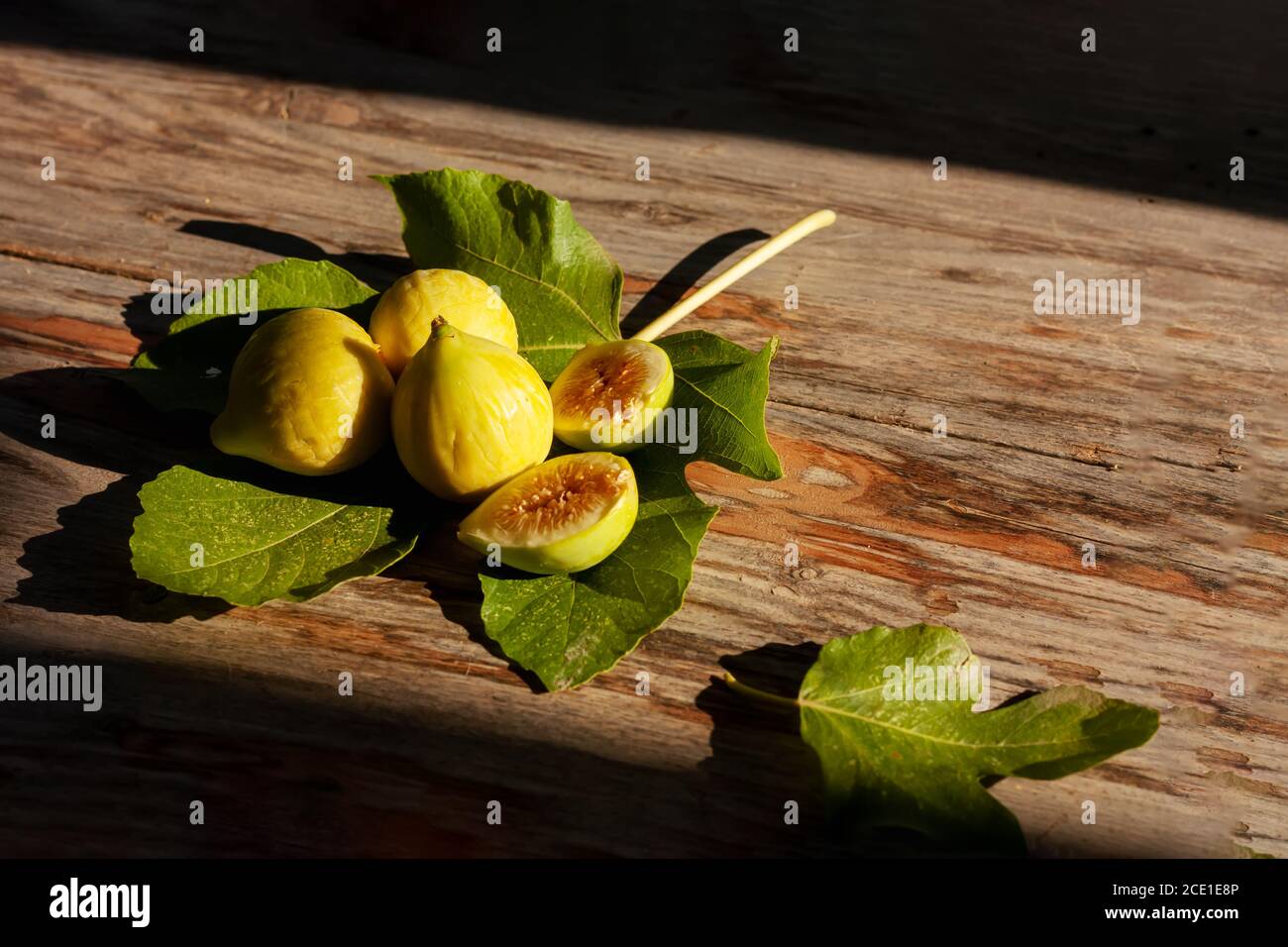 Ripe yellow fig fruit with leaf on wooden table. Harvest and healthy ...