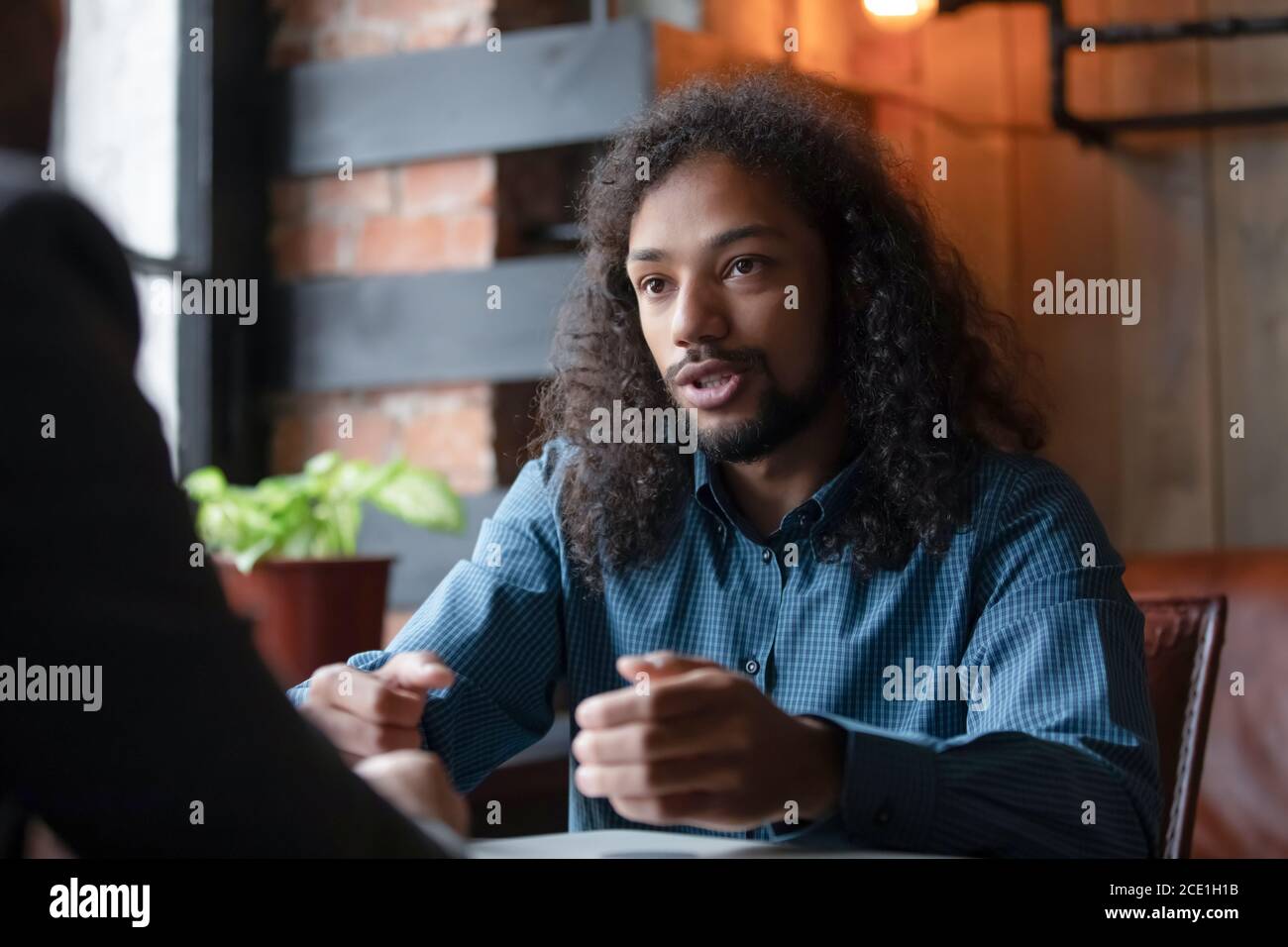 Confident African American candidate speaking on job interview in cafe ...