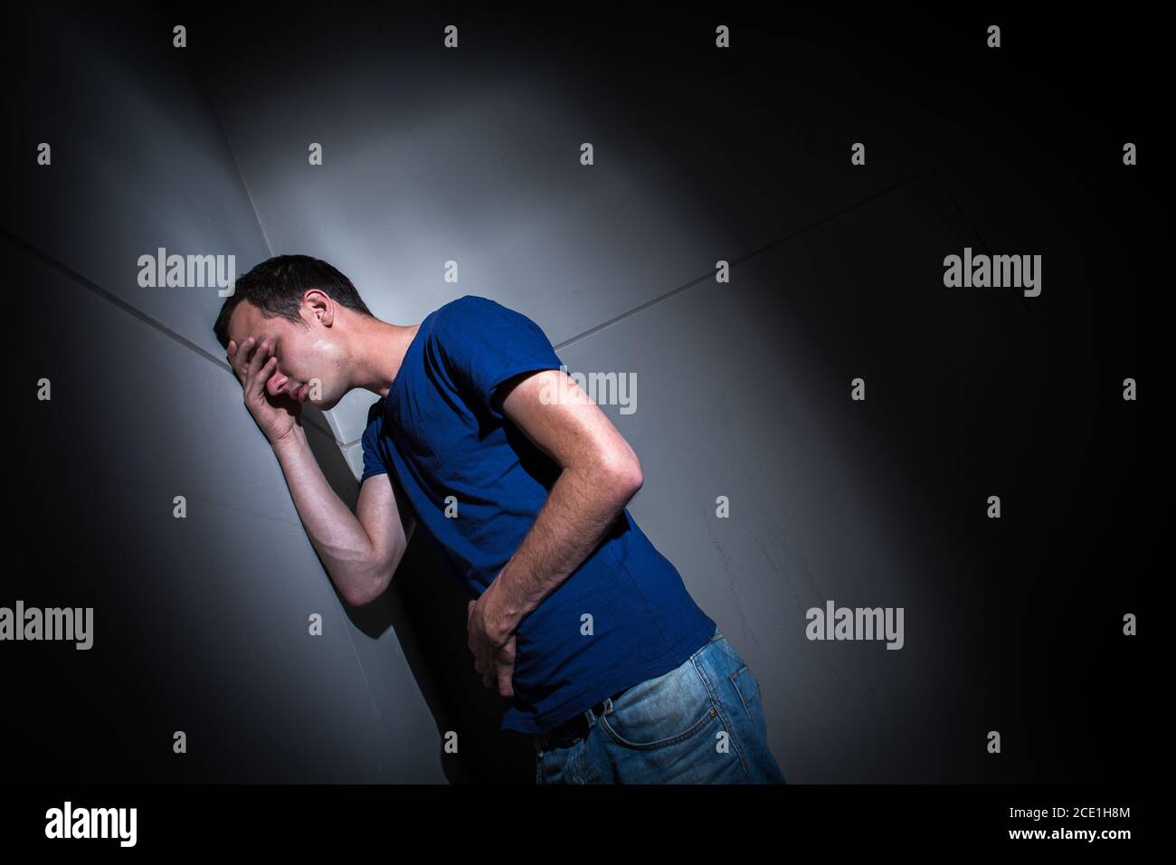 Young man suffering from severe belly pain, being cornered by the ...