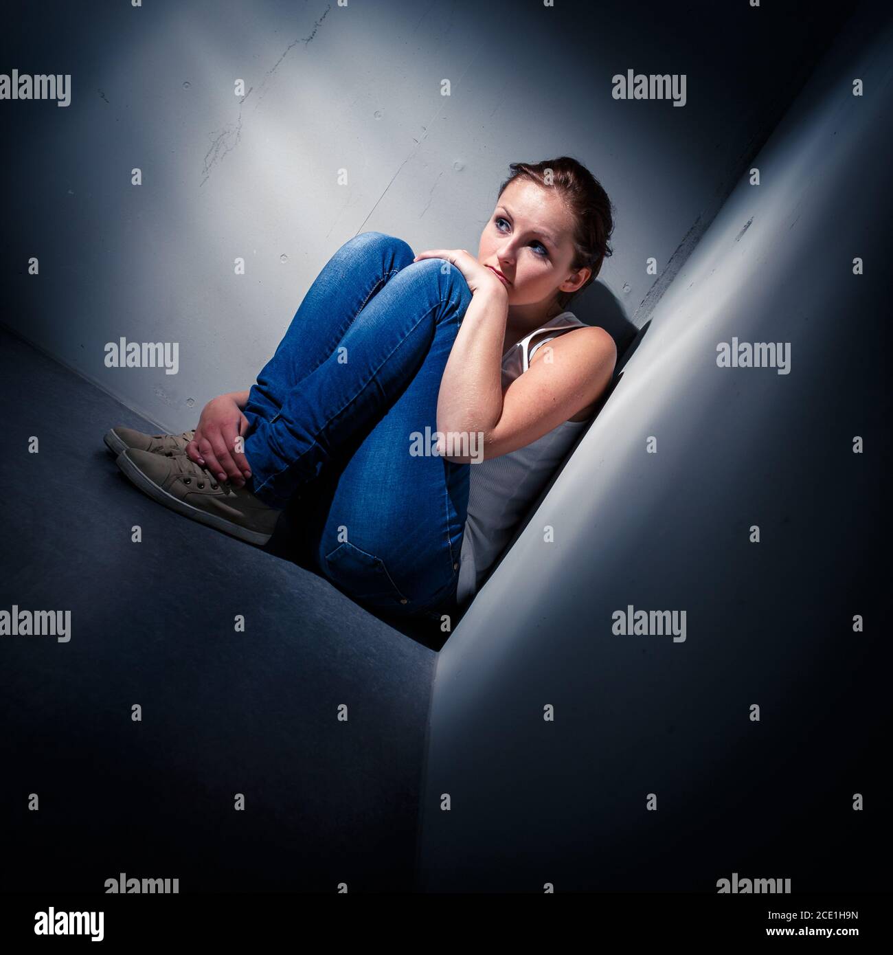 Young woman suffering from a severe depression (very harsh lighting is ...