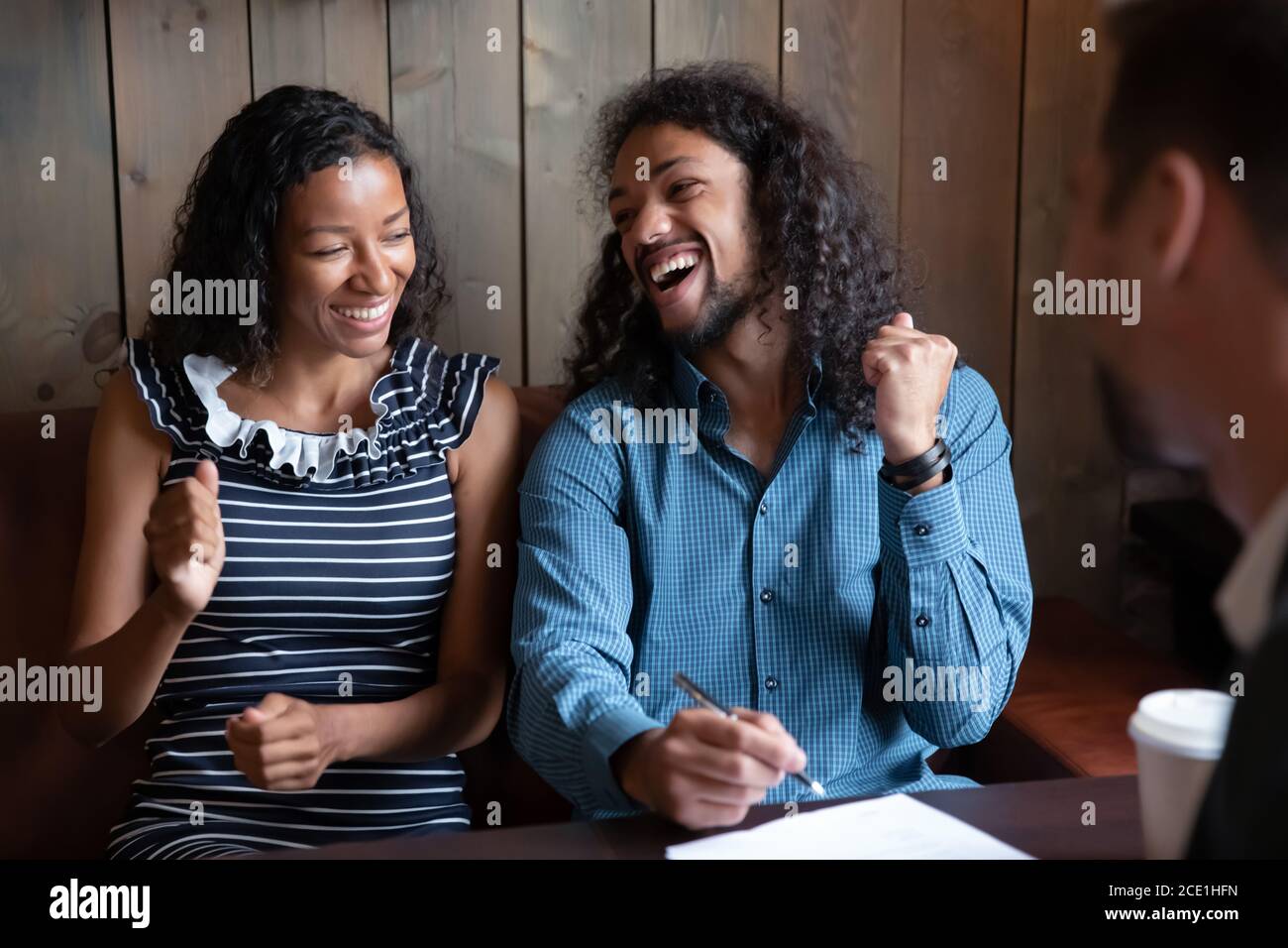 Overjoyed young African American couple celebrating, making successful ...