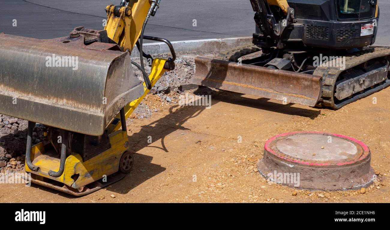 Civil engineering excavator on a sidewalk construction site Stock Photo ...