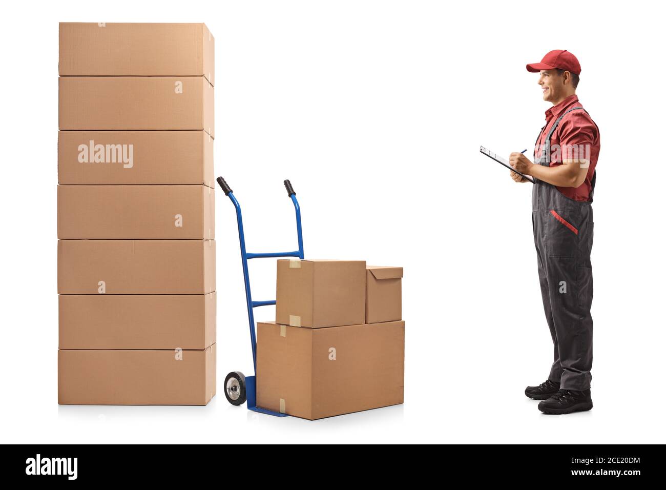 Full length profile shot of a worker counting boxes and writing a ...