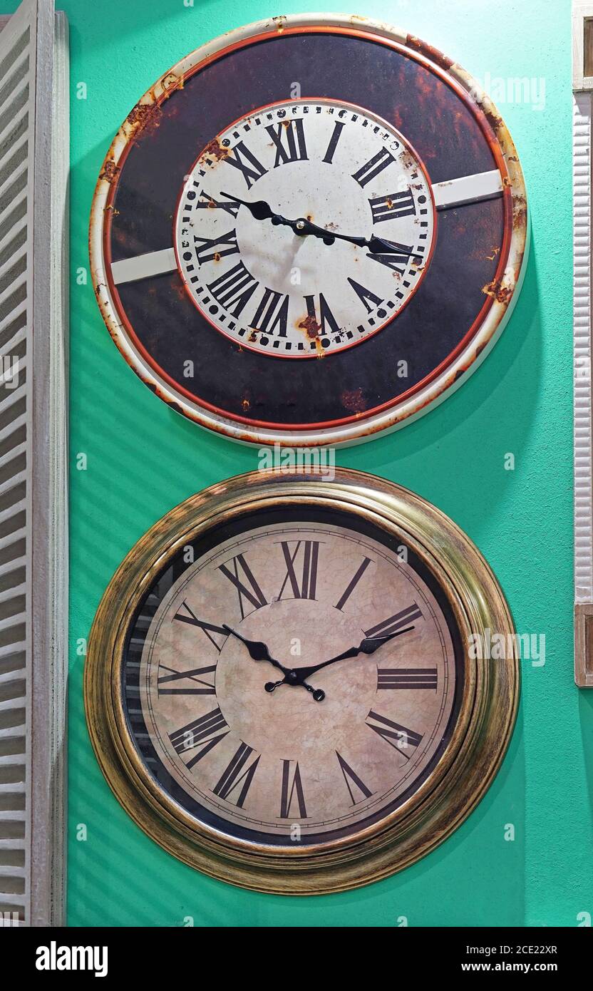 Two big vintage round clock at green wall Stock Photo - Alamy