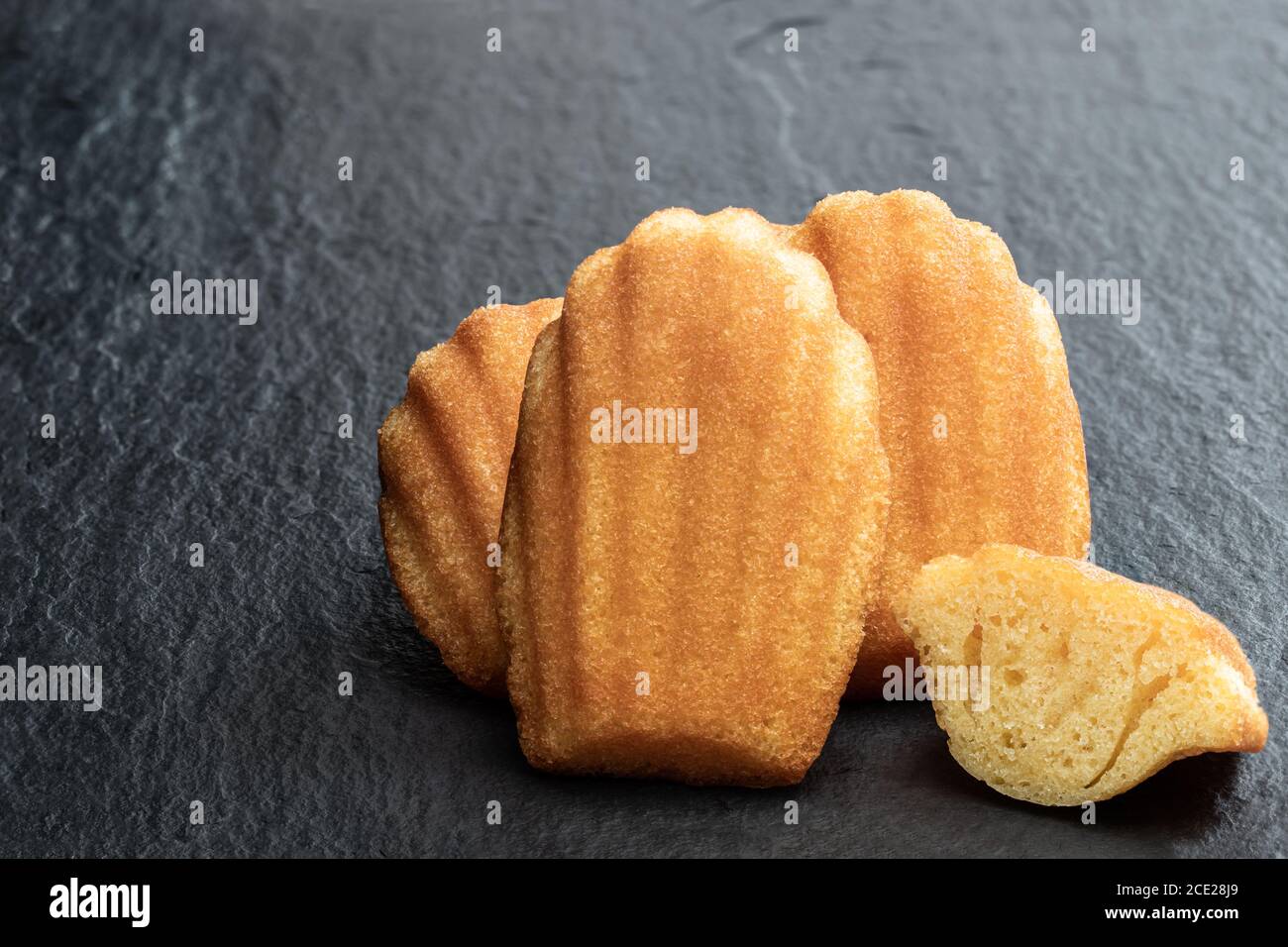 Homemade madeleines french sponge cake on black stone background Stock ...