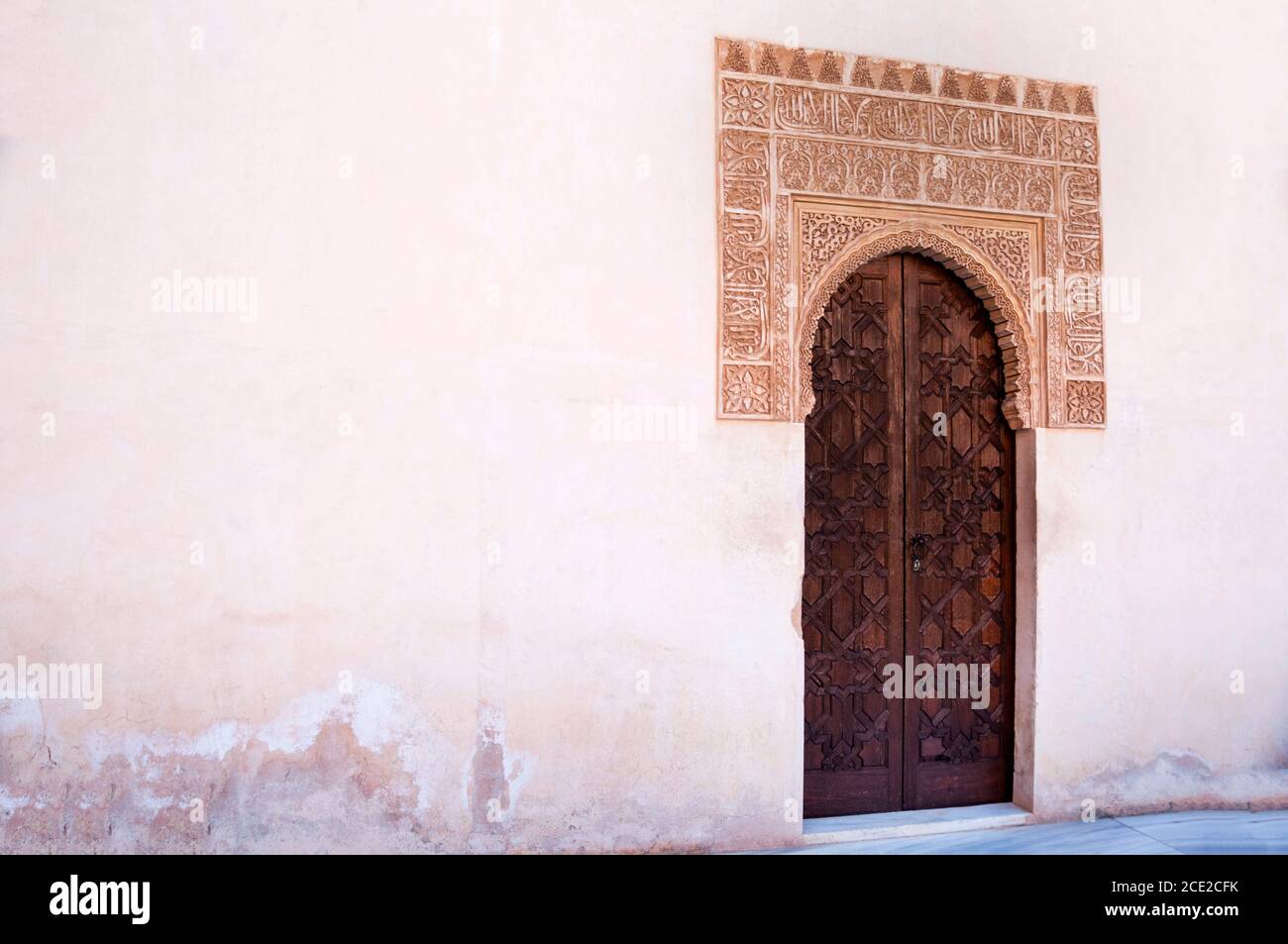 Calligraphy and motifs surround carved door at Alhambra Palace, Granada ...