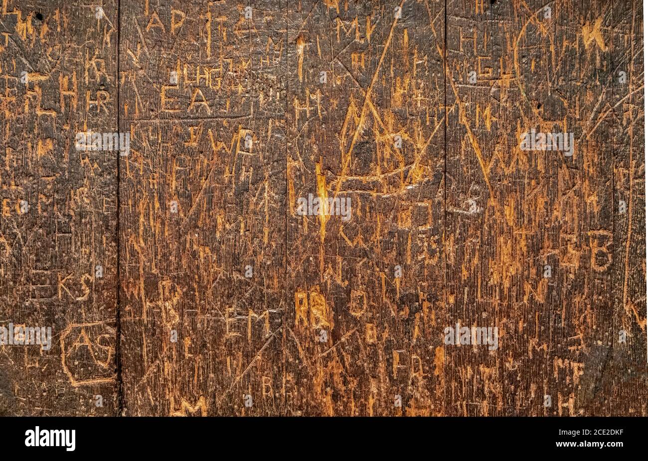 old wooden surface covered with lots of engraved graffiti tags Stock ...
