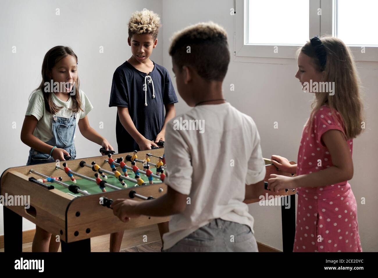 Mixed race children playing football hi-res stock photography and ...