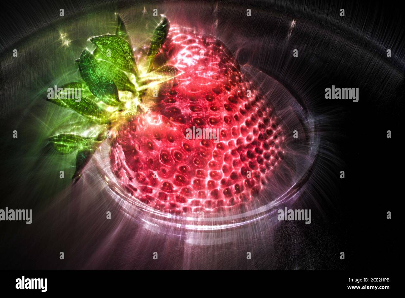 Kirlian glow at strawberries with leaves on a plate in a glas bowl ...