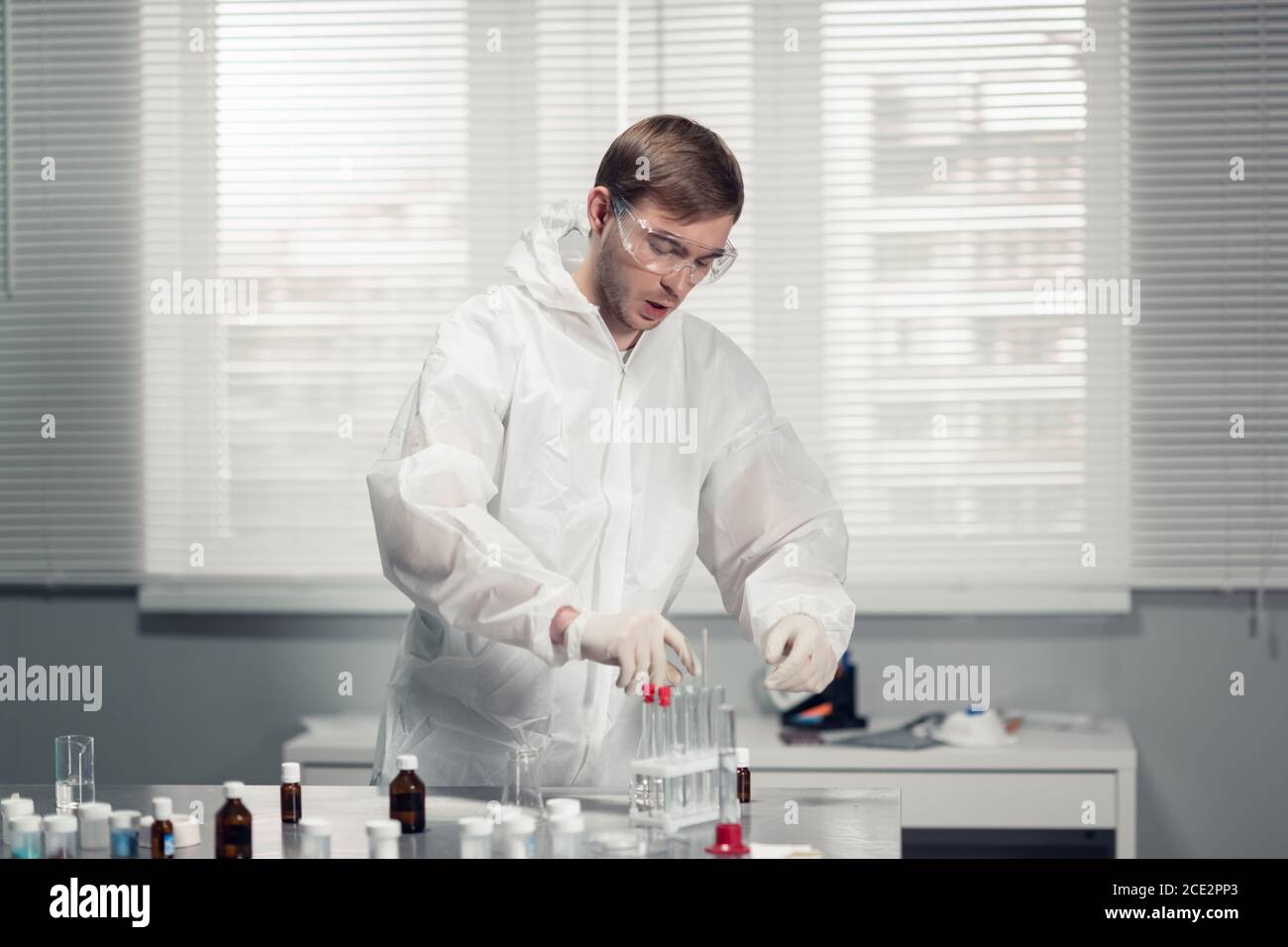 Laboratory assistant putting test tubes into the holder Stock Photo - Alamy