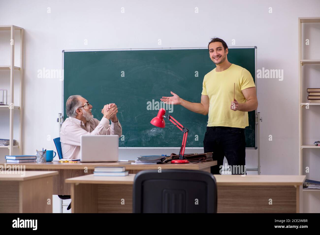 Old teacher and young student in the classroom Stock Photo - Alamy