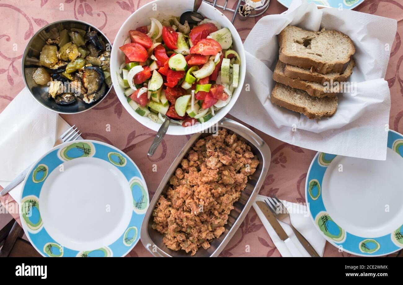 Top view of a Greek lunch meal at summer with omellete, horiatiki salad ...