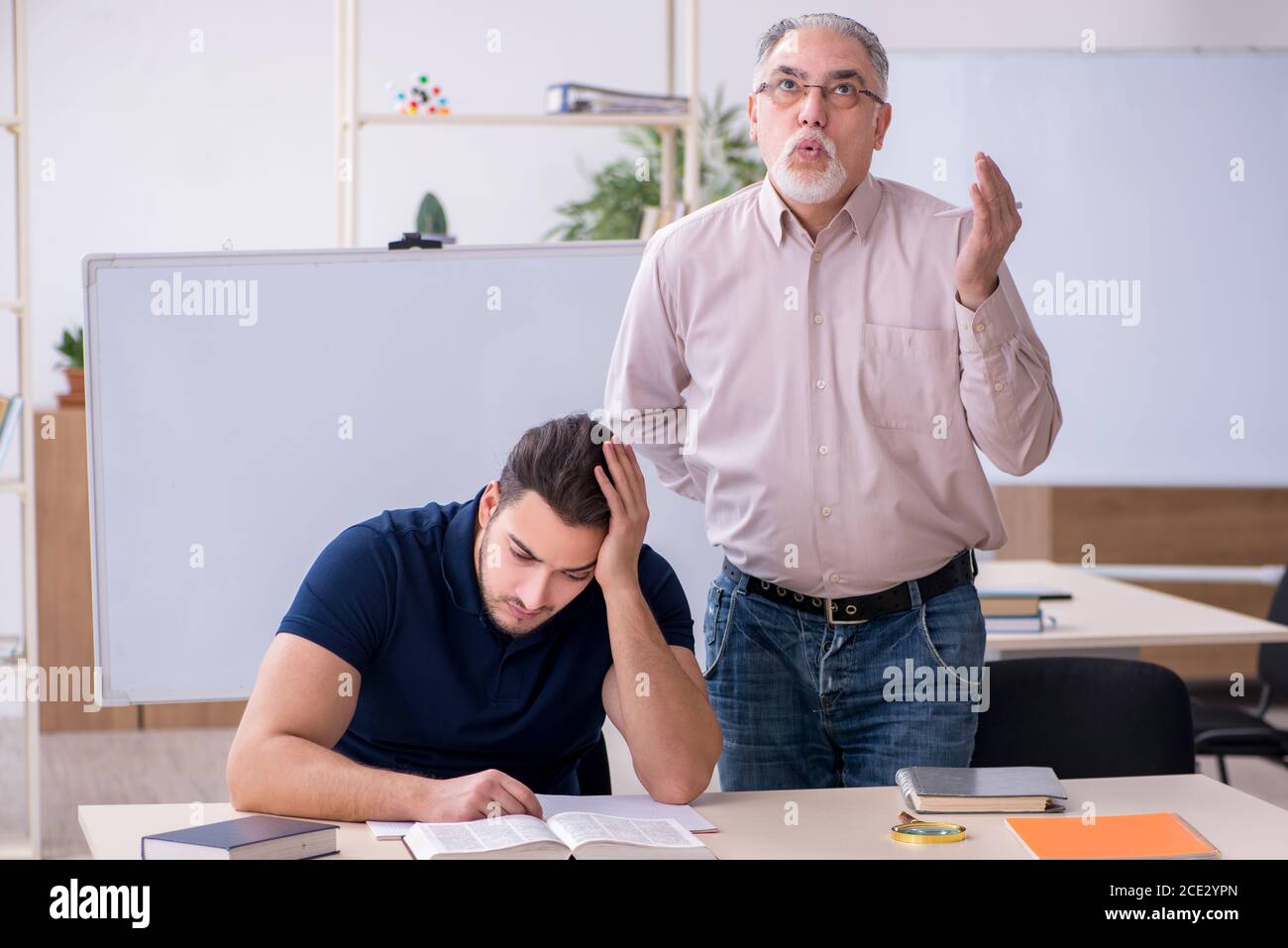 Old teacher and young student in the classroom Stock Photo - Alamy