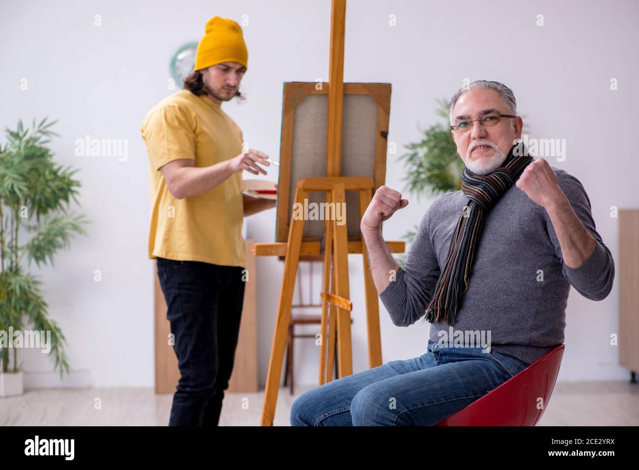 Young portraitist and old model Stock Photo - Alamy