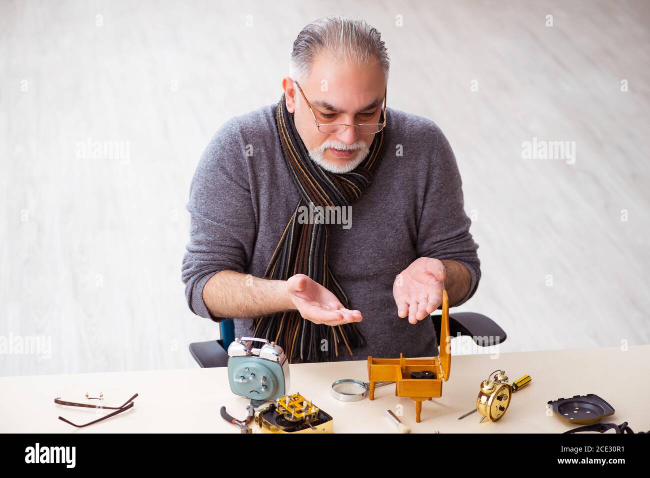 Old watchmaker working in the workshop Stock Photo - Alamy