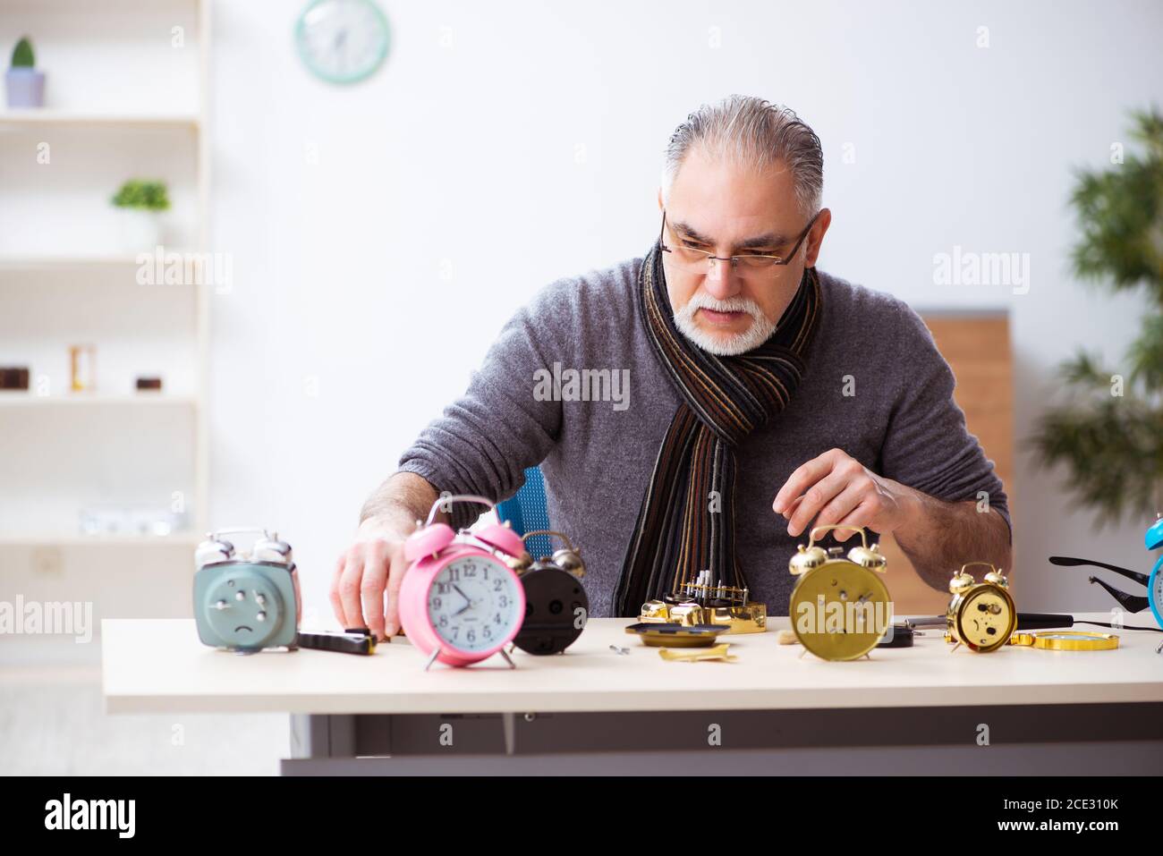 Old watchmaker working in the workshop Stock Photo - Alamy