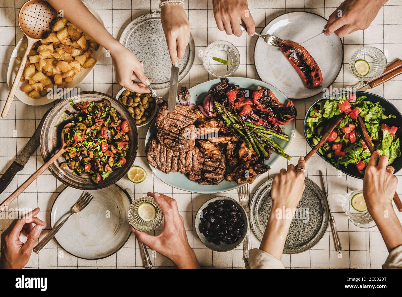 Flat-lay of people having dinner with frilled meat and vegetables Stock ...