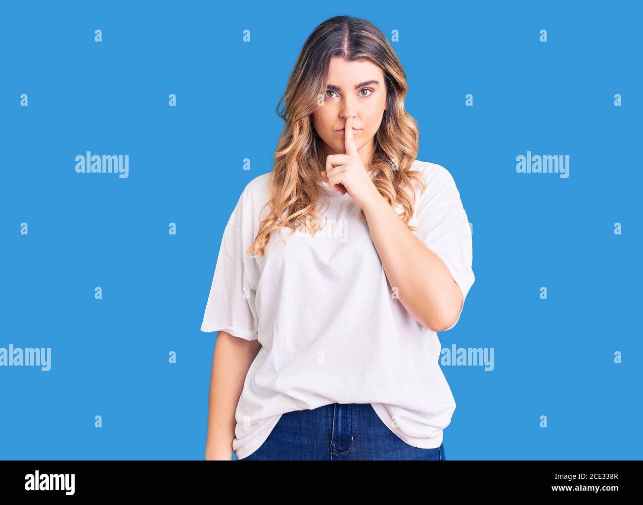 Young caucasian woman wearing casual clothes asking to be quiet with ...