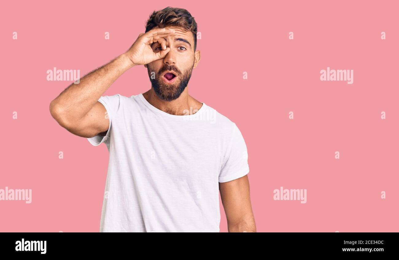 Young hispanic man wearing casual white tshirt doing ok gesture shocked ...