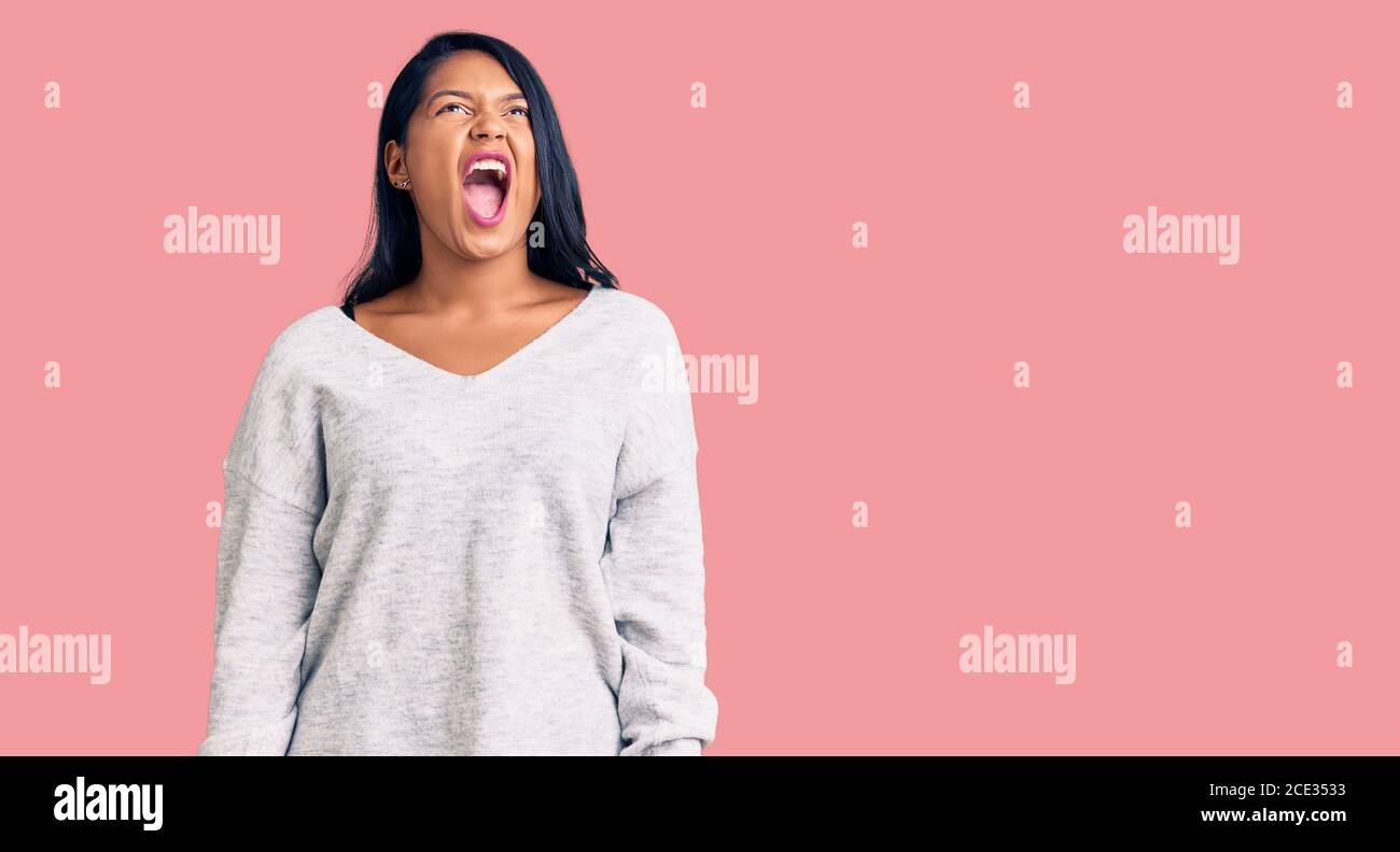 Hispanic woman with long hair wearing casual clothes angry and mad ...