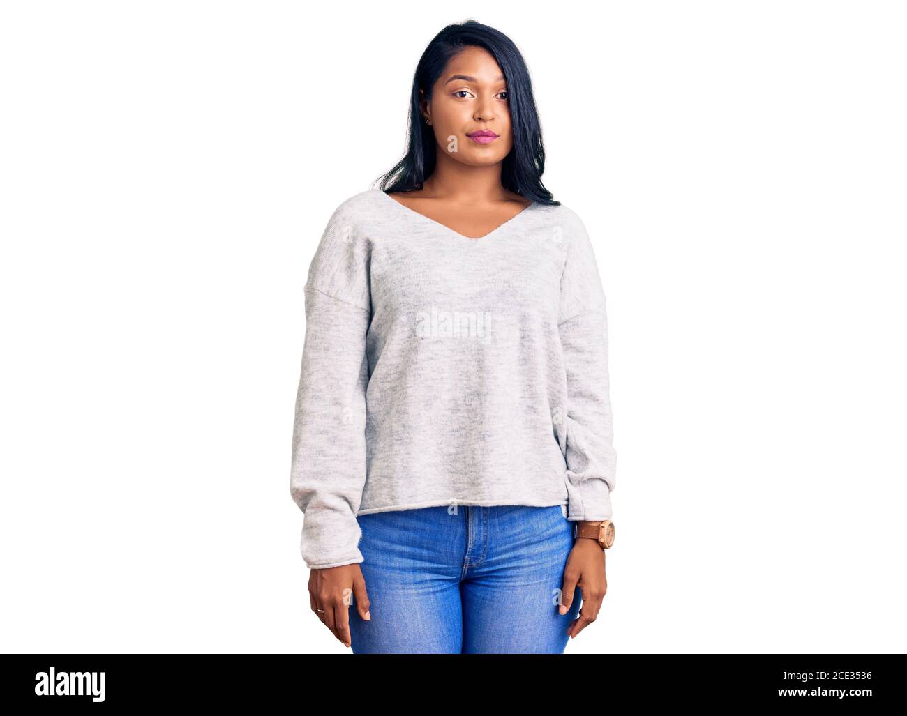 Hispanic woman with long hair wearing casual clothes skeptic and ...