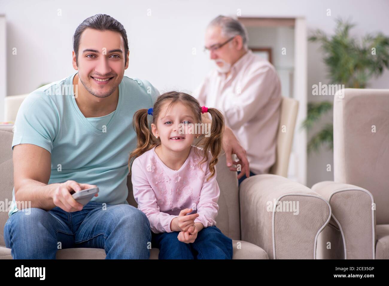 Three generations family watching tv hi-res stock photography and ...
