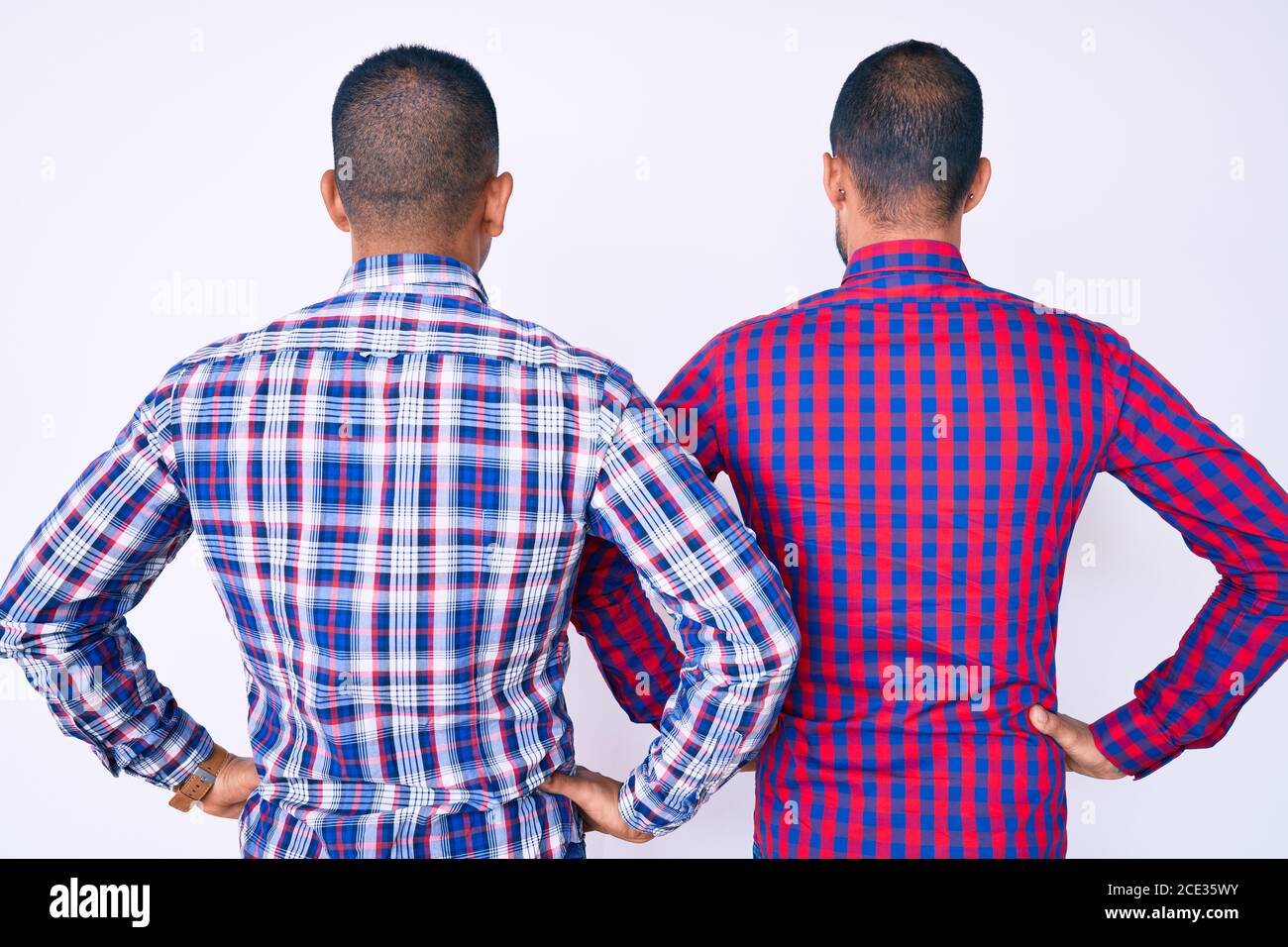 Young gay couple of two men wearing casual clothes standing backwards ...