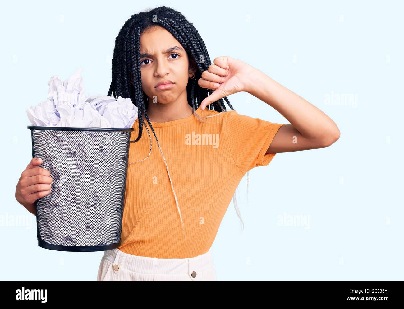 Cute african american girl holding paper bin full of crumpled papers ...