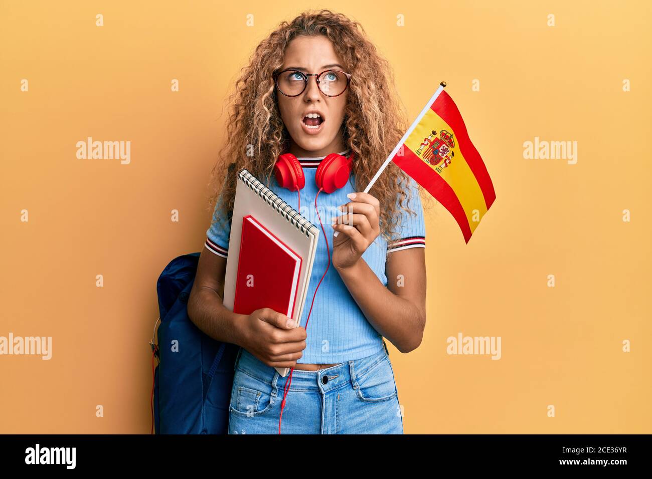 Beautiful caucasian teenager girl exchange student holding spanish flag ...