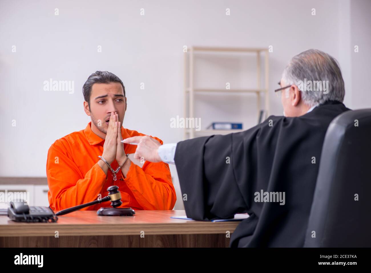 Old judge meeting with young captive in courthouse Stock Photo - Alamy