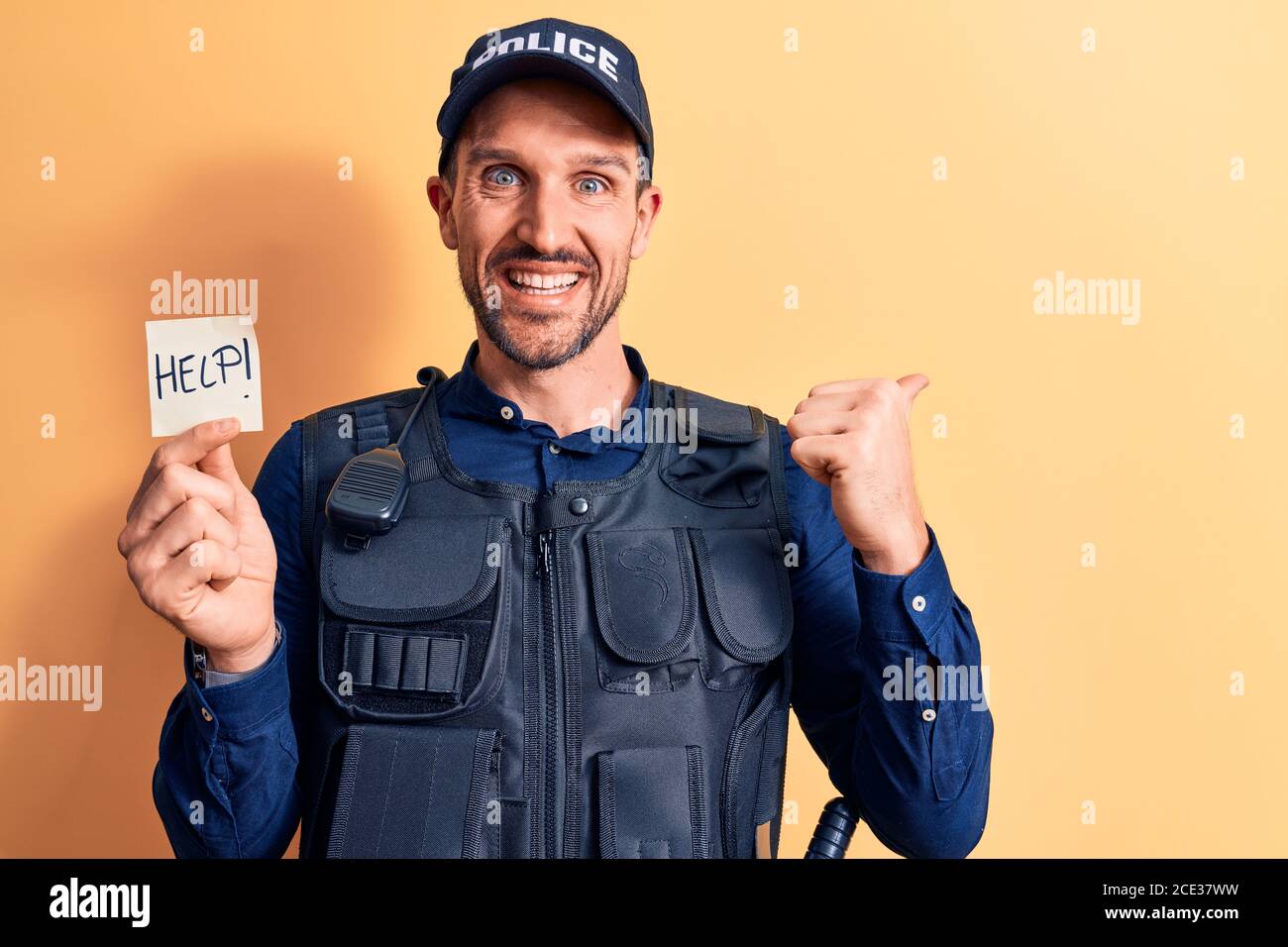 Handsome policeman wearing uniform and bulletprof holding reminder with ...