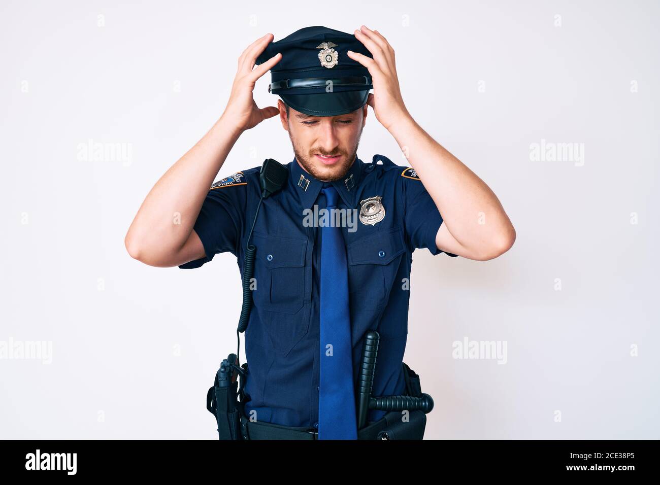 Young caucasian man wearing police uniform suffering from headache ...