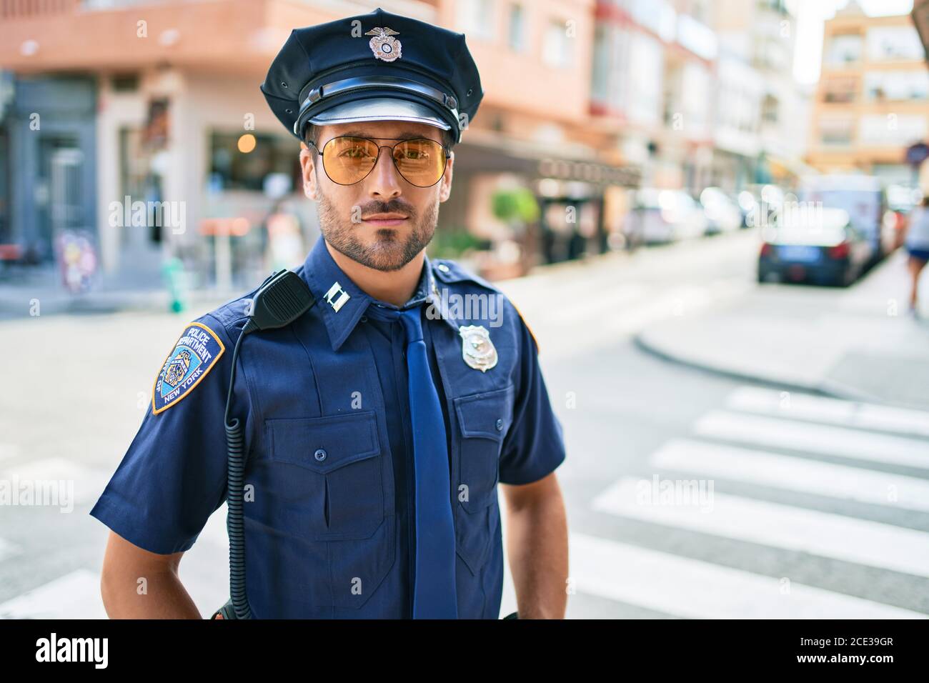 Young handsome hispanic policeman wearing police uniform smiling happy ...