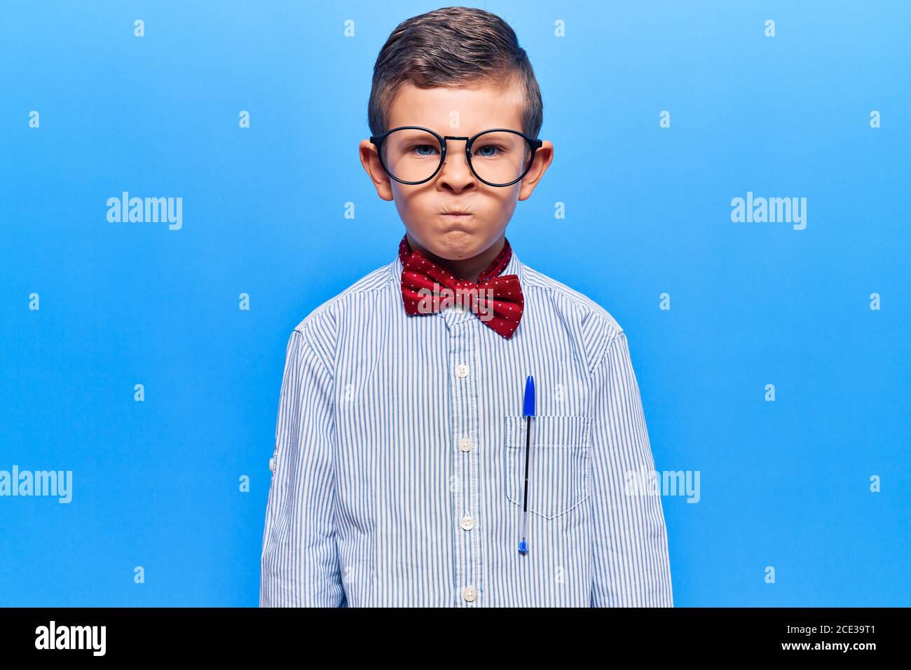 Cute blond kid wearing nerd bow tie and glasses skeptic and nervous ...