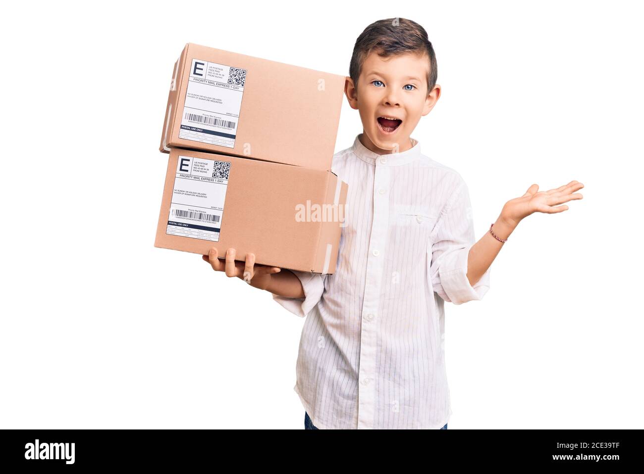 Cute blond kid holding delivery package celebrating victory with happy ...