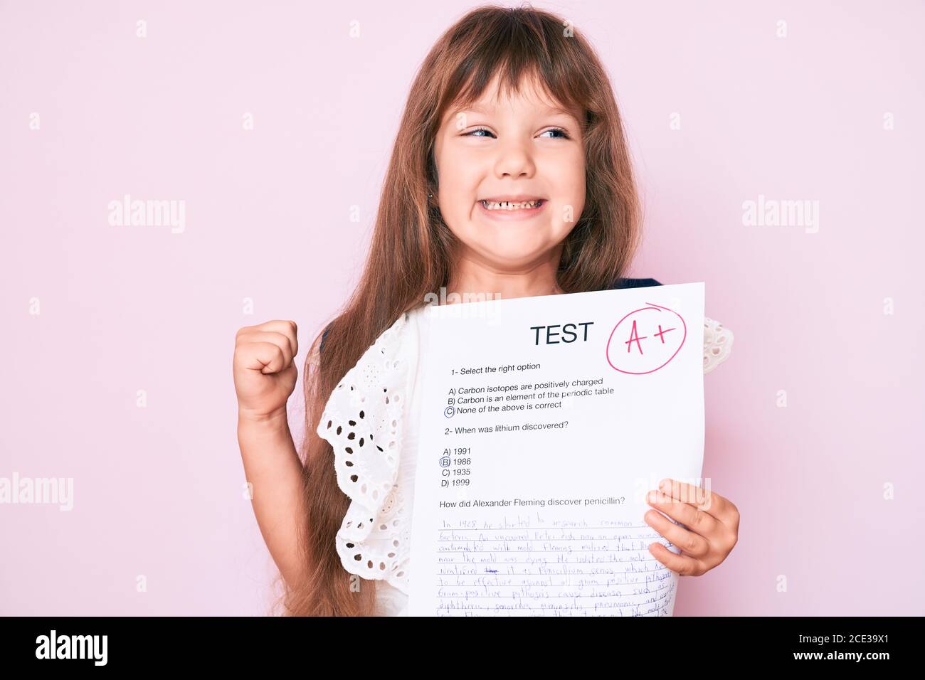 Little caucasian kid girl with long hair showing a passed exam from ...
