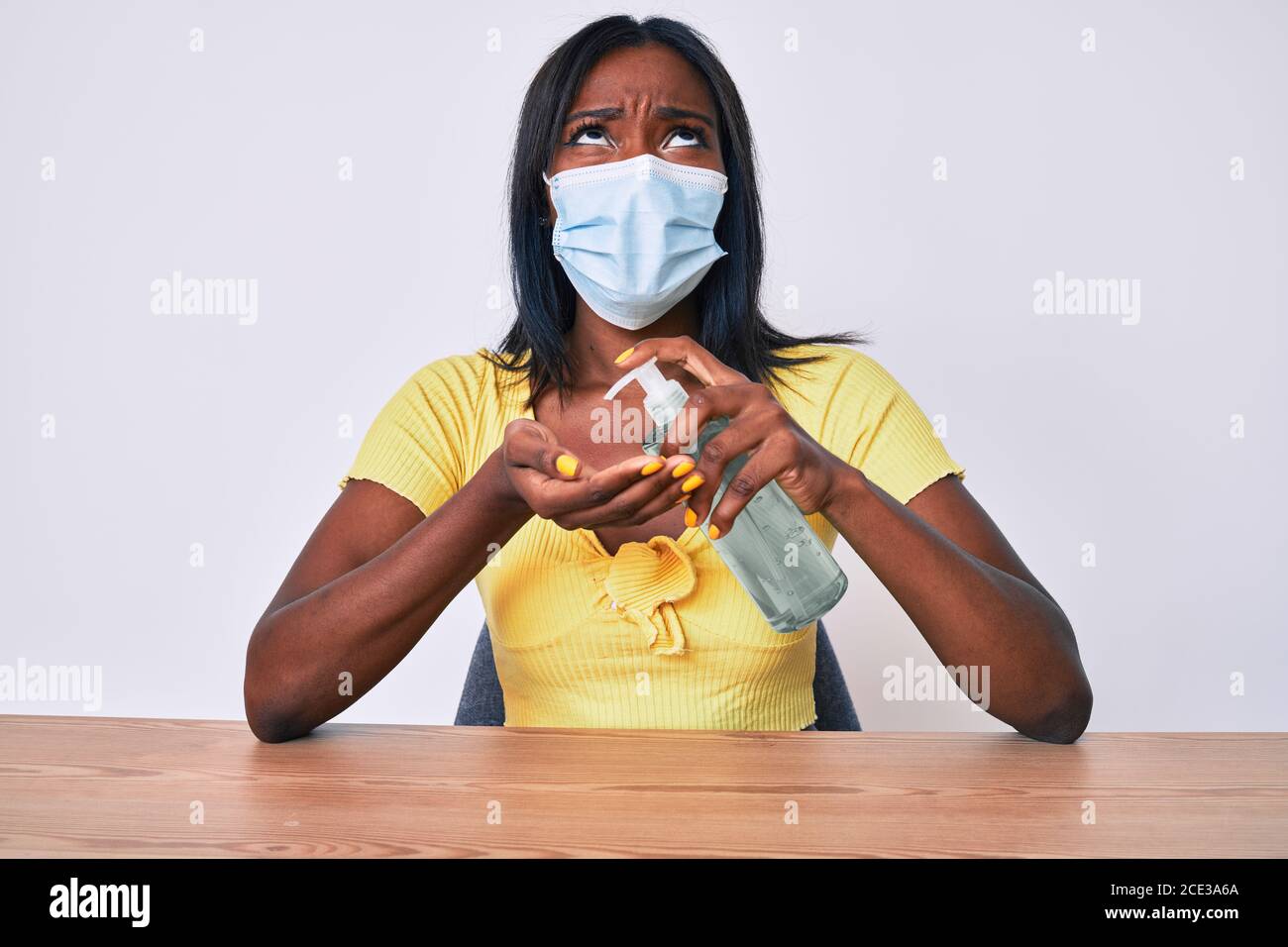 Young african american woman wearing medical mask holding hand ...