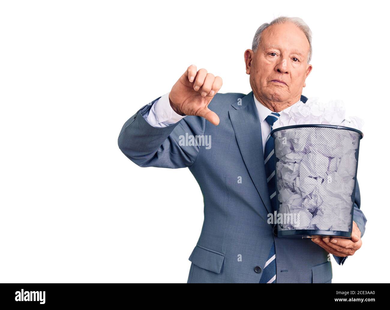 Senior handsome grey-haired man holding paper bin with crumpled ...