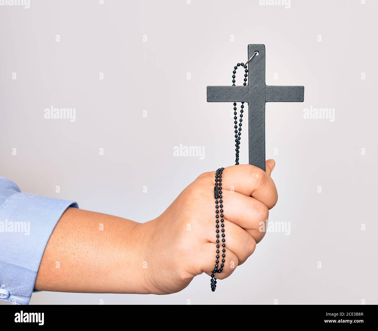 Hand of caucasian young catholic woman holding christian cross over ...