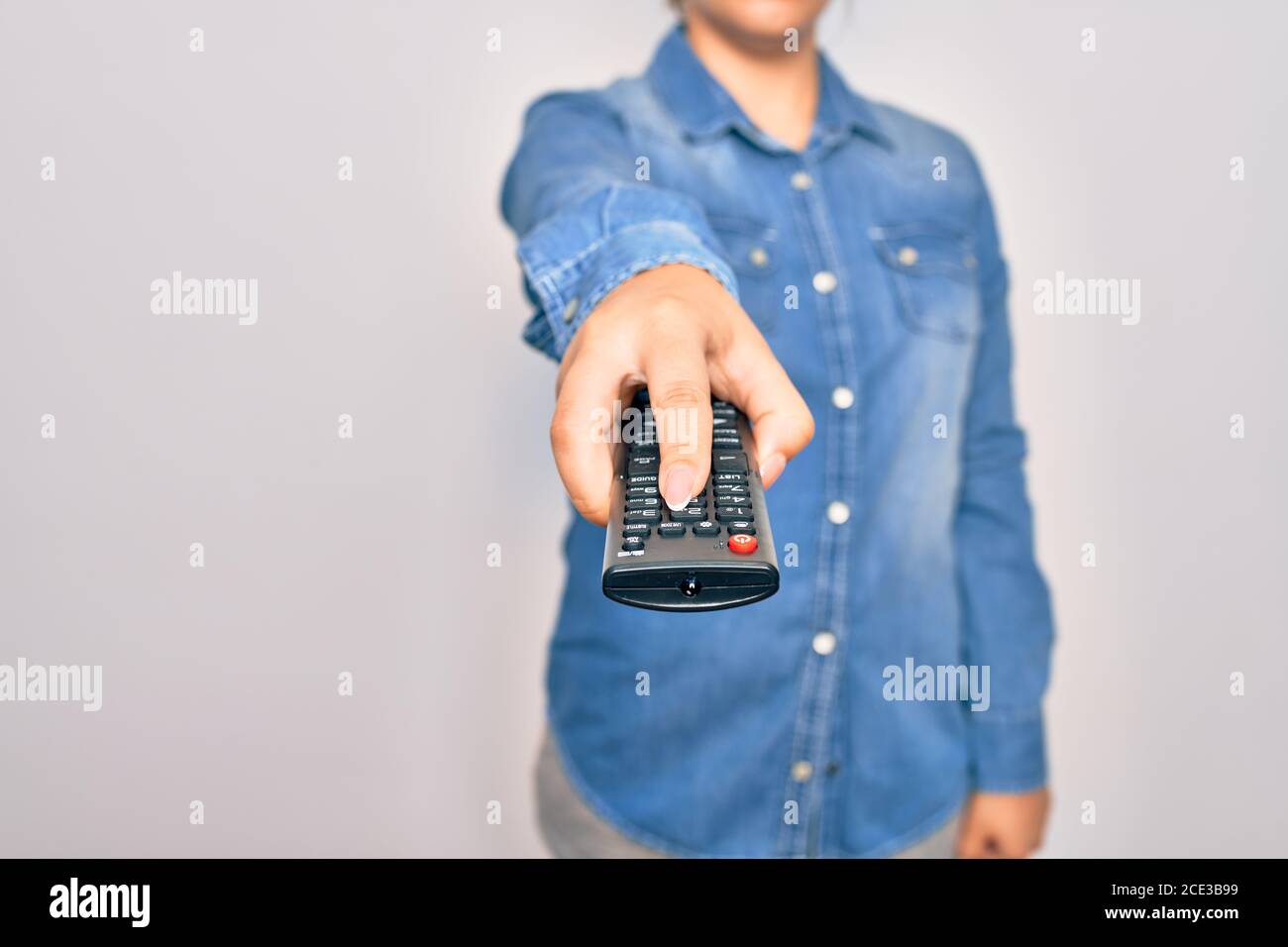 Woman changing television channel holding tv remote control. Standing ...