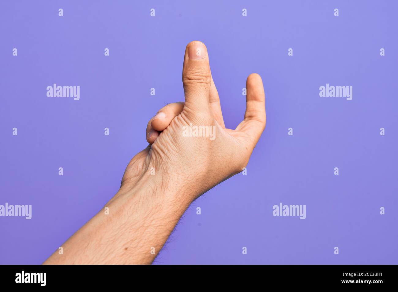Hand of caucasian young man showing fingers over isolated purple ...