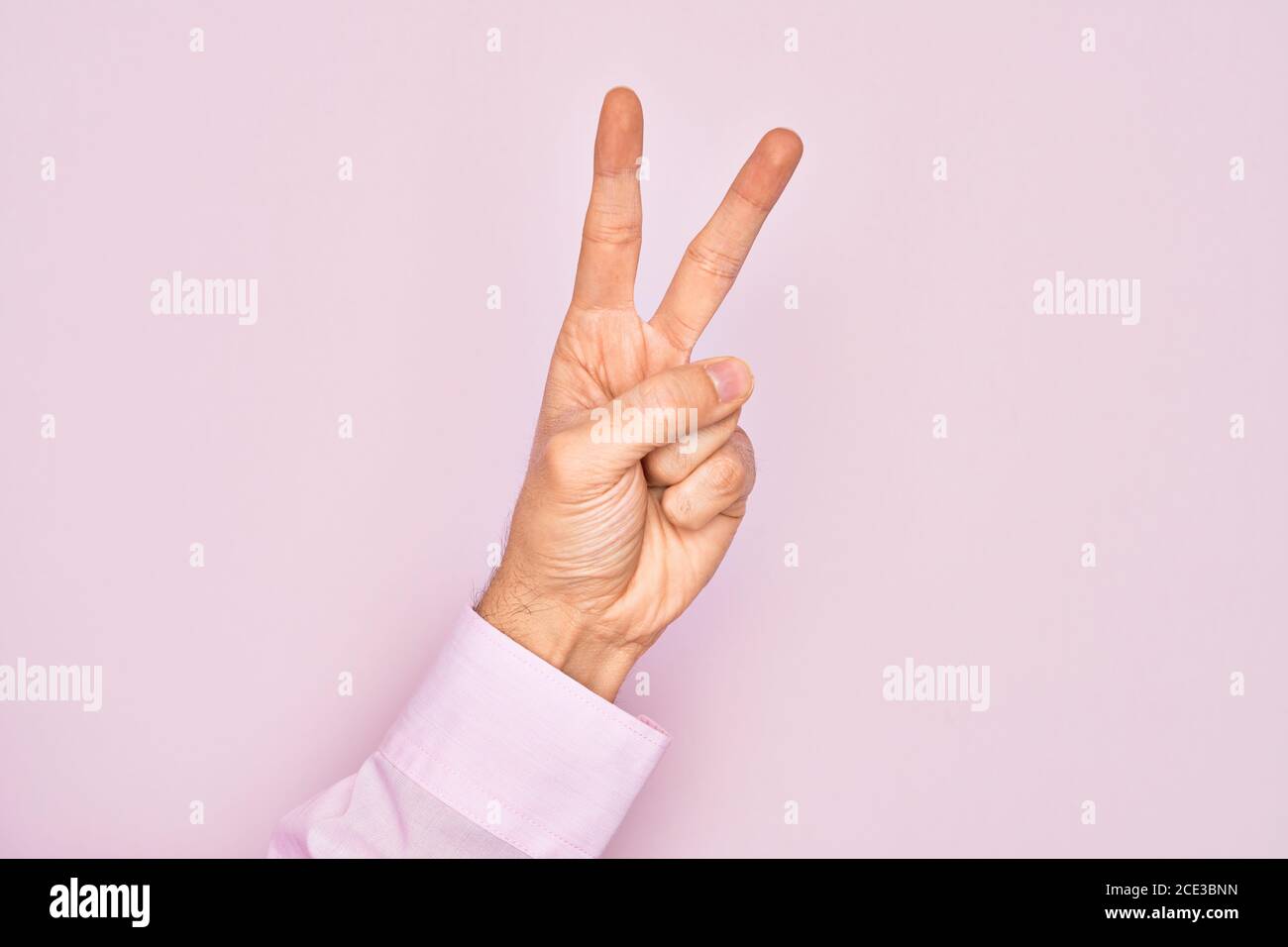 Hand of caucasian young man showing fingers over isolated pink ...