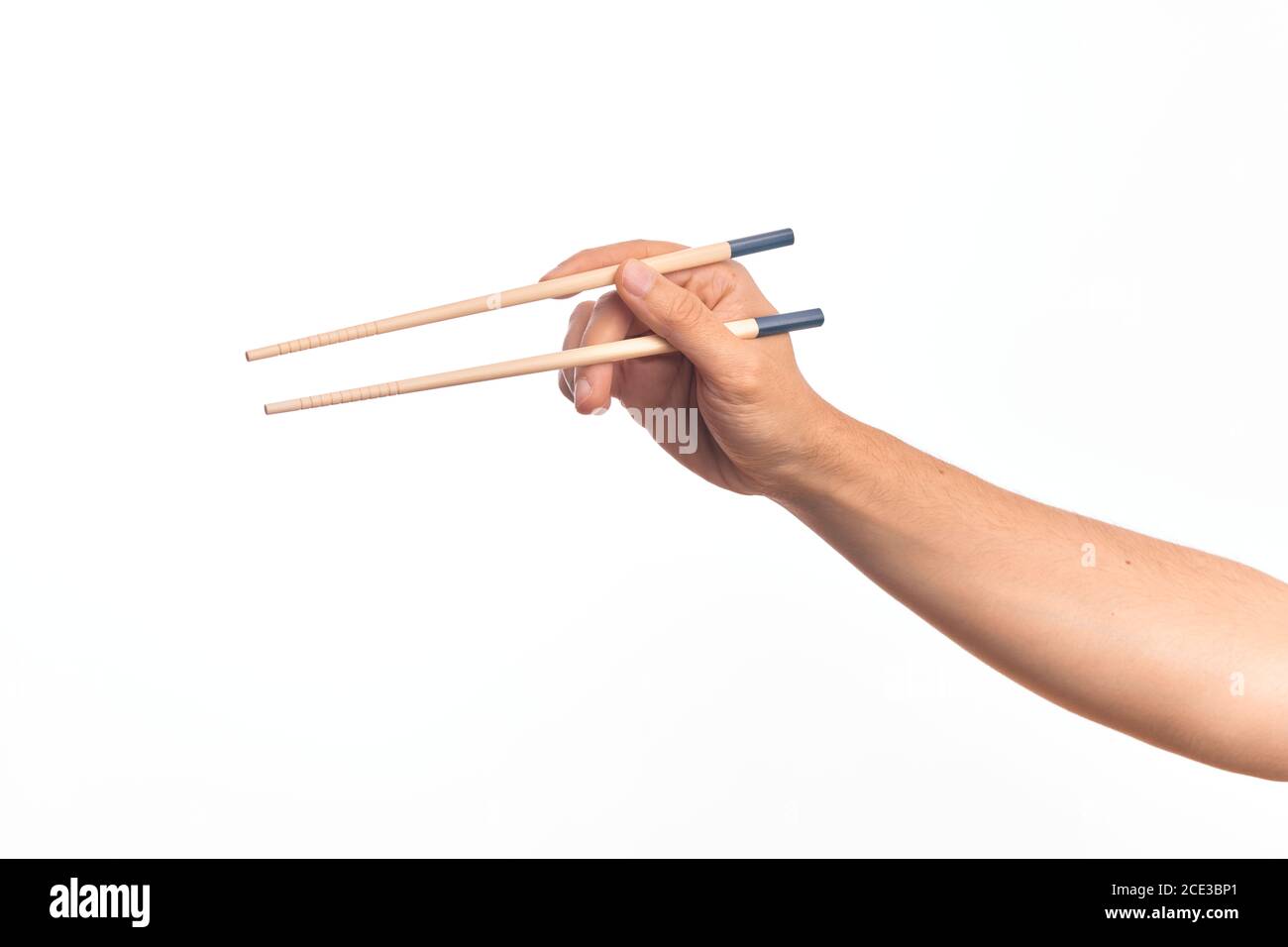 Hand of caucasian young man holding chopsticks over isolated white ...